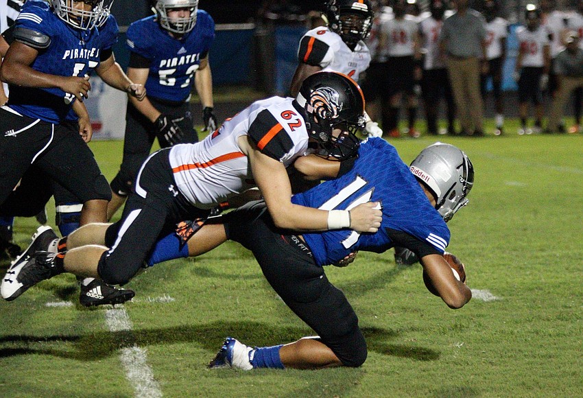 Business Observer | Photo - Defensive end Aaron Benson tackles a ...