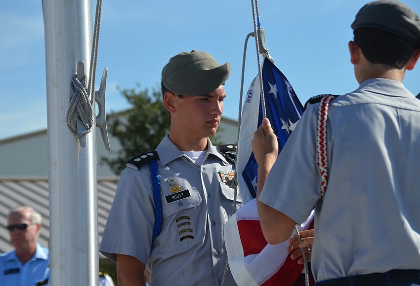 Your Observer | Photo - Houston Scott helps raise the flag.