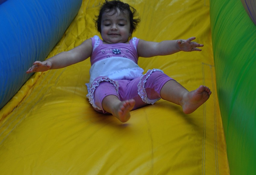 Your Observer | Photo - Sophie Rivers, 2, goes down an inflatable slide.