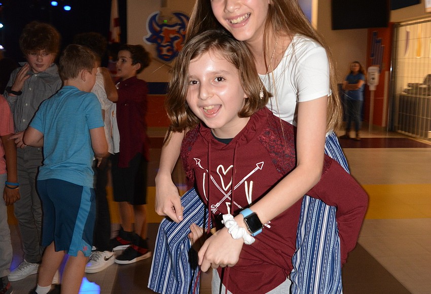 Your Observer | Photo - Maya Gilkison gets a piggyback ride from friend ...