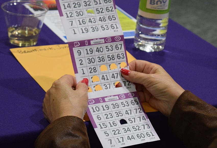 Your Observer | Photo - Women punch their Bingo cards.
